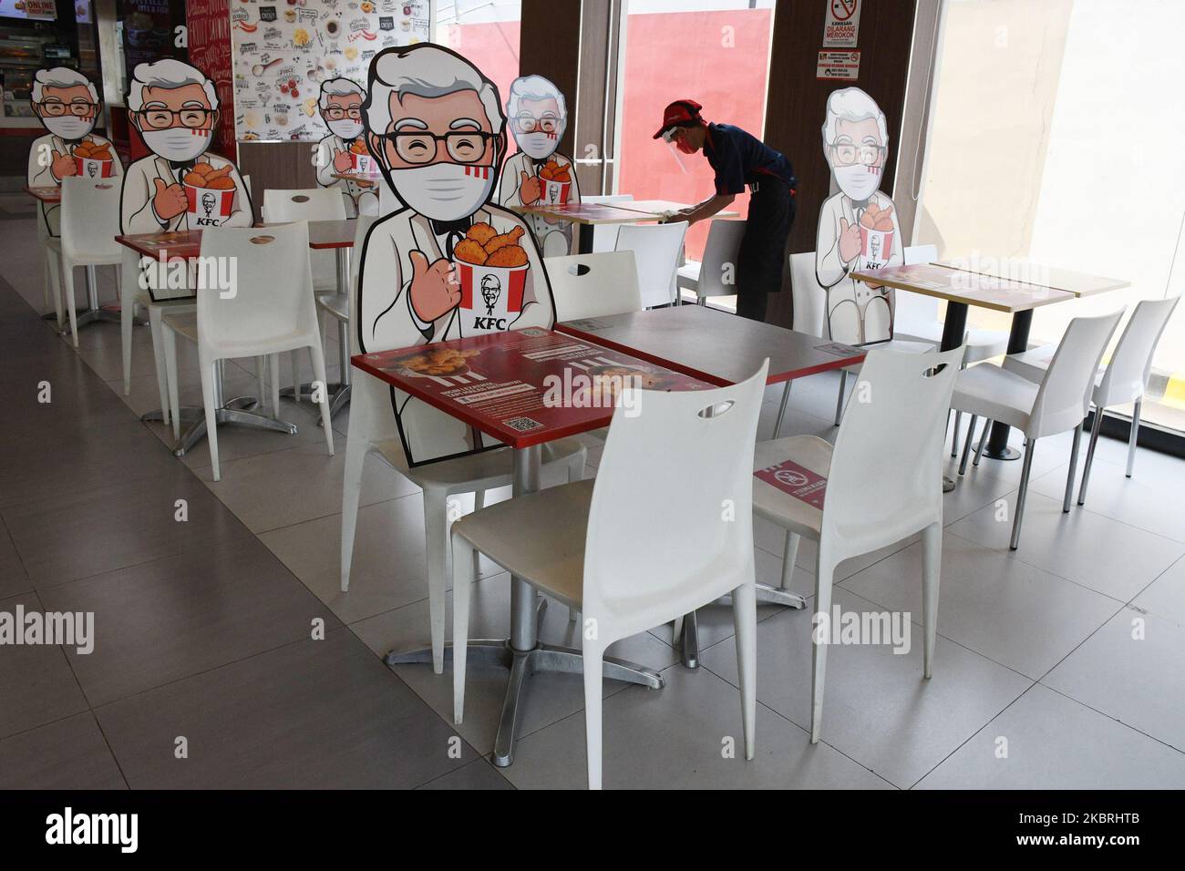 Waiters tidy up tables and draw KFC (Kentucky Fried Chicken) characters ...