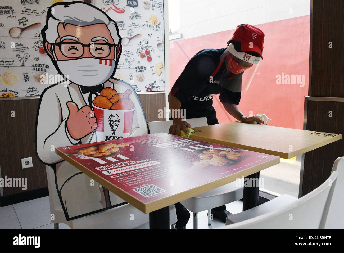 Waiters tidy up tables and draw KFC (Kentucky Fried Chicken) characters ...