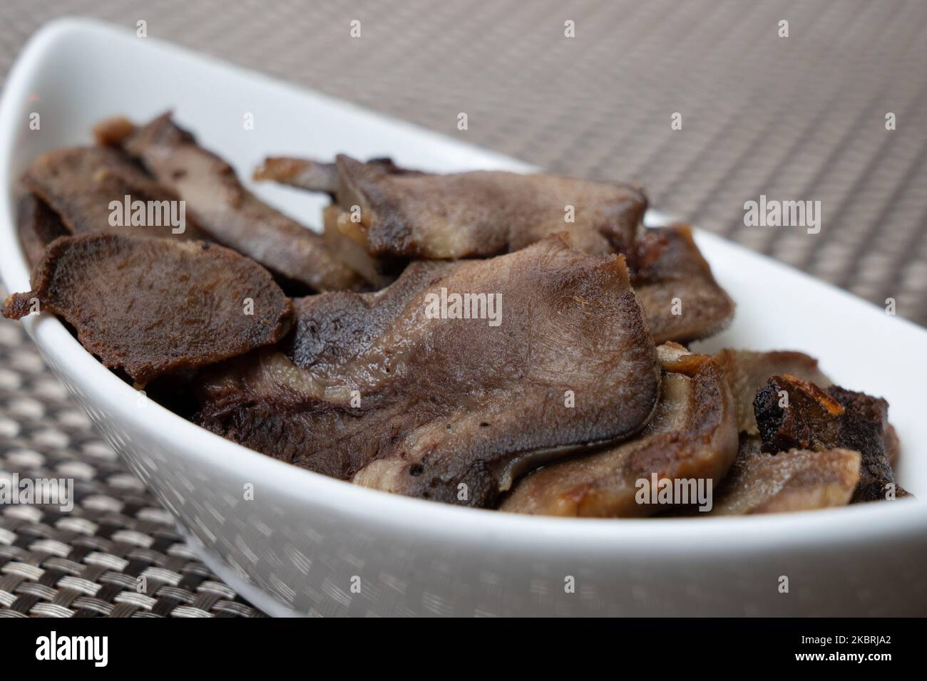 A dish filled with Pan Fried Cheley which is fried buff tongue Stock ...