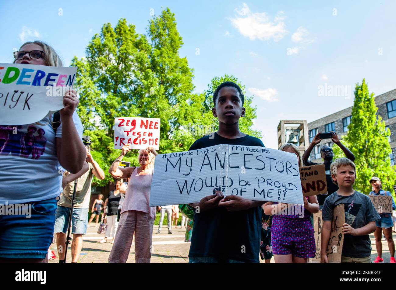 A Black boy is holding a placard against racism, during the first Black ...