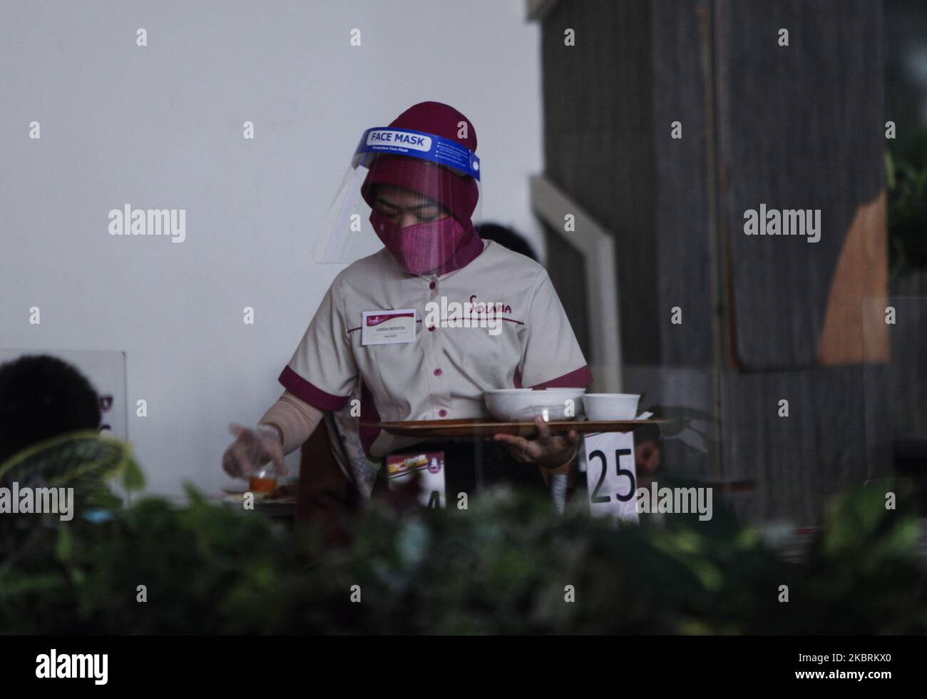 A employee wear face shield, serve of the customers during restaurant ...