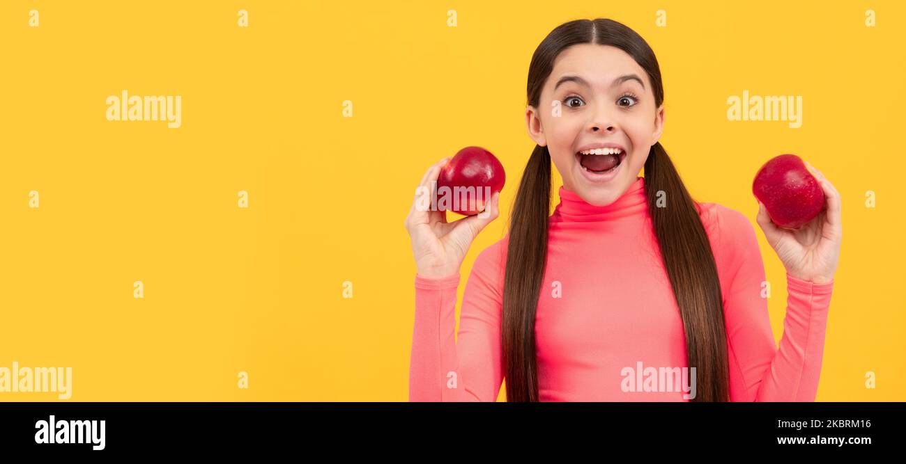 surprised child with red apple on yellow background. Child girl ...