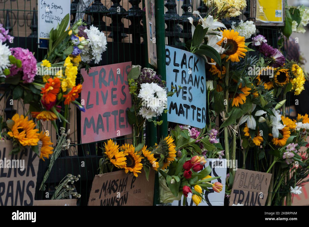 Flowers and placards are left attached to the railings at Westminster ...