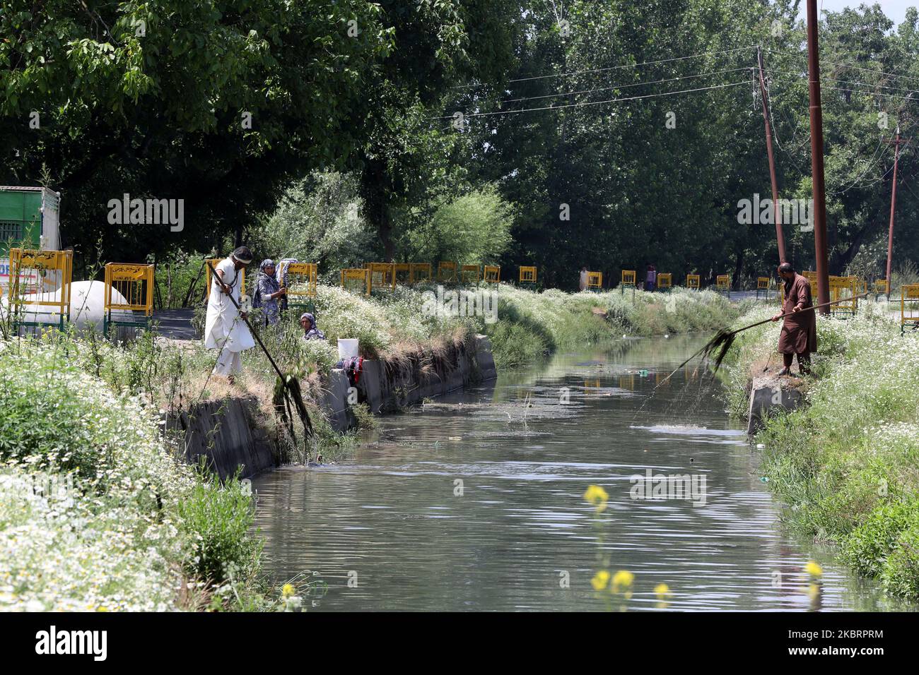 Kashmiri men clean a stream on a hot summer day in Sopore town of ...