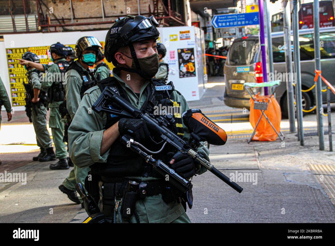 A police officer waits with a pepper-ball gun in hand during street ...