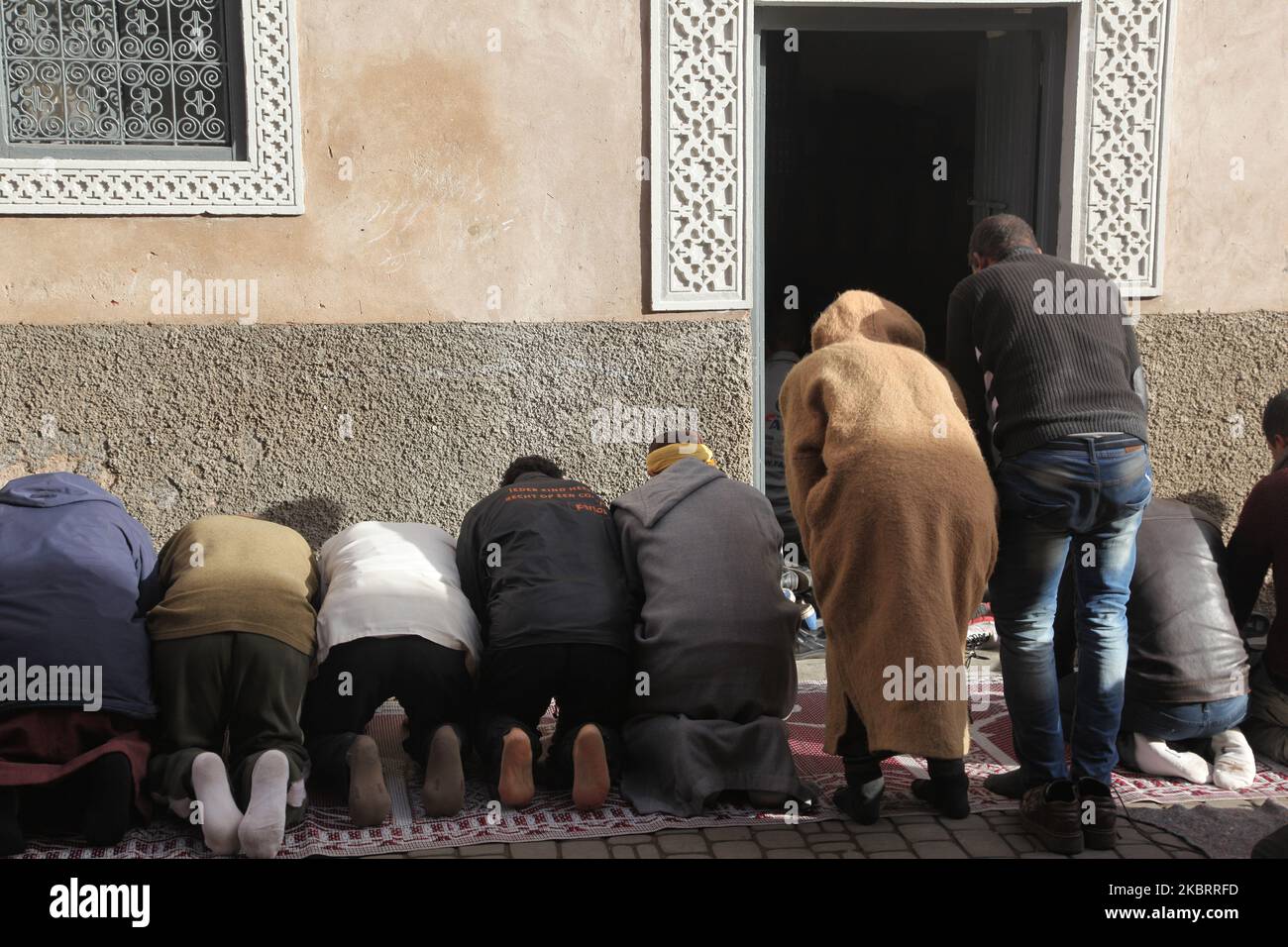 Muslim devotees offer prayers along the roadside during the afternoon ...