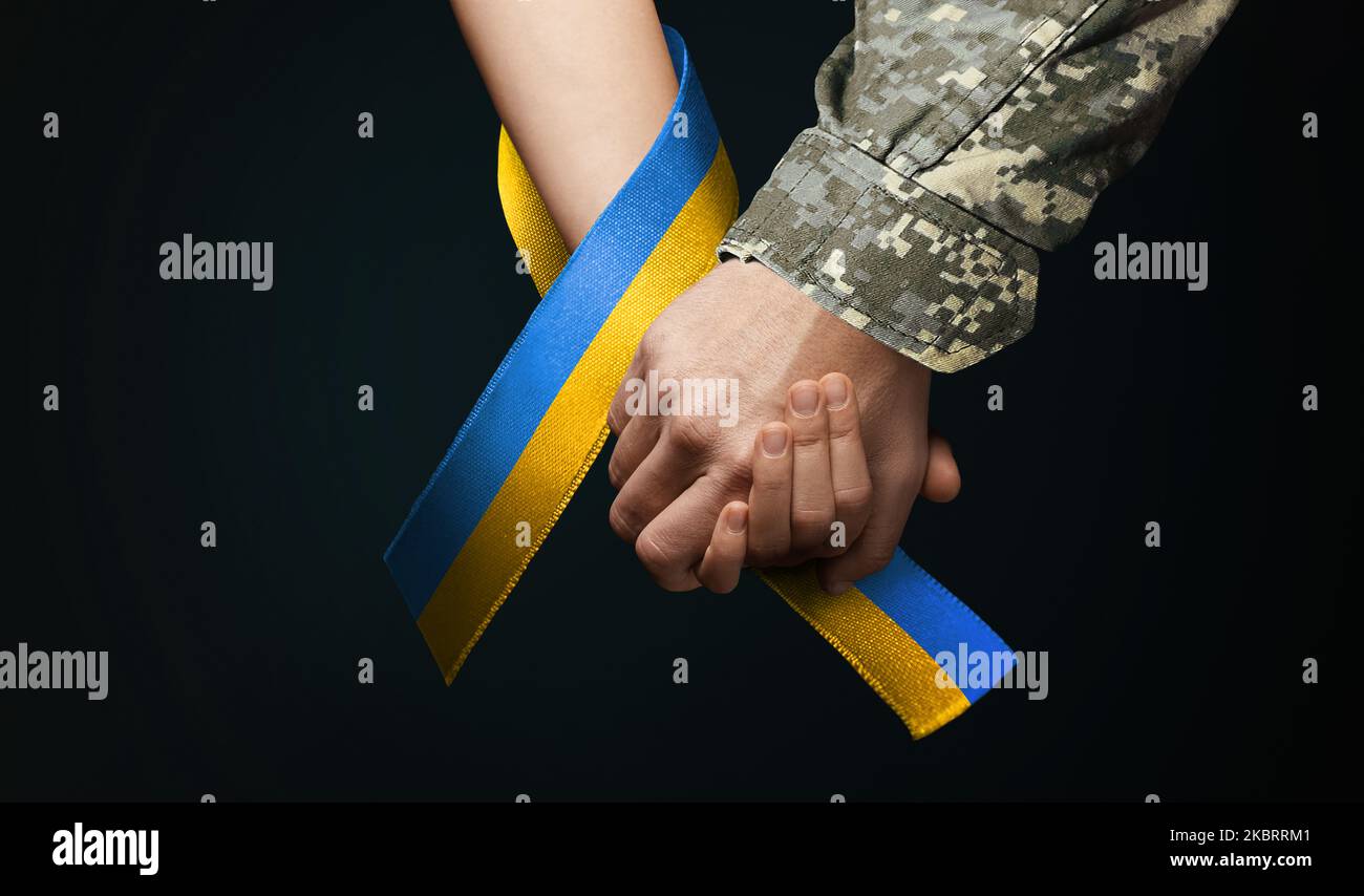 military man holds tightly hand of child Stock Photo - Alamy
