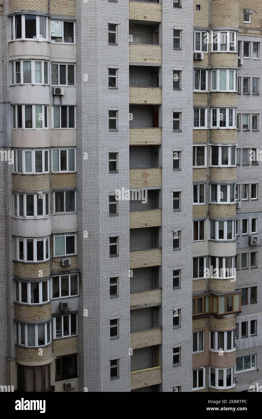 Facade of a budget high-rise building made of white brick with small ...