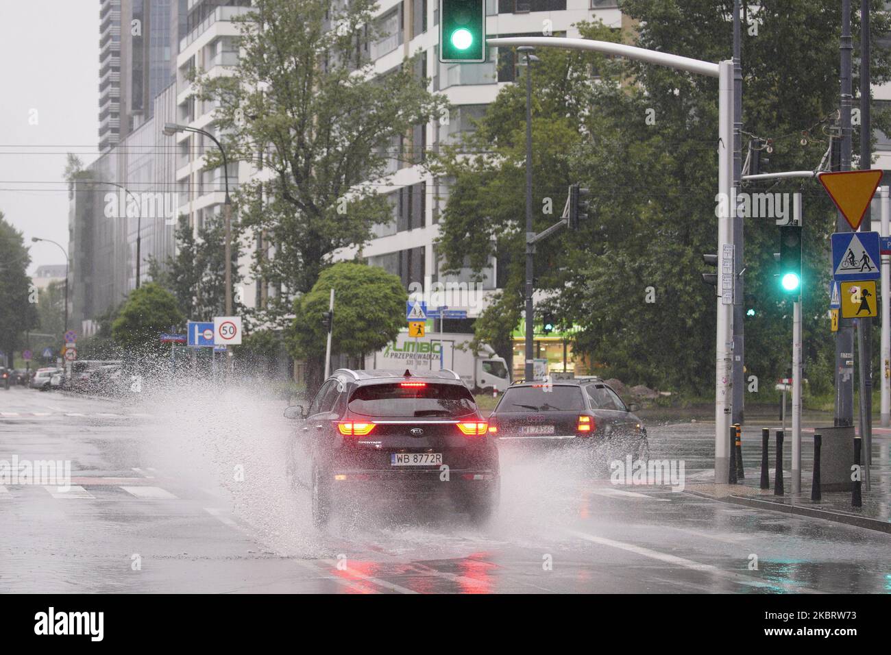 A car drives through a puddle or rain water on June 29, 2020 in Warsaw ...