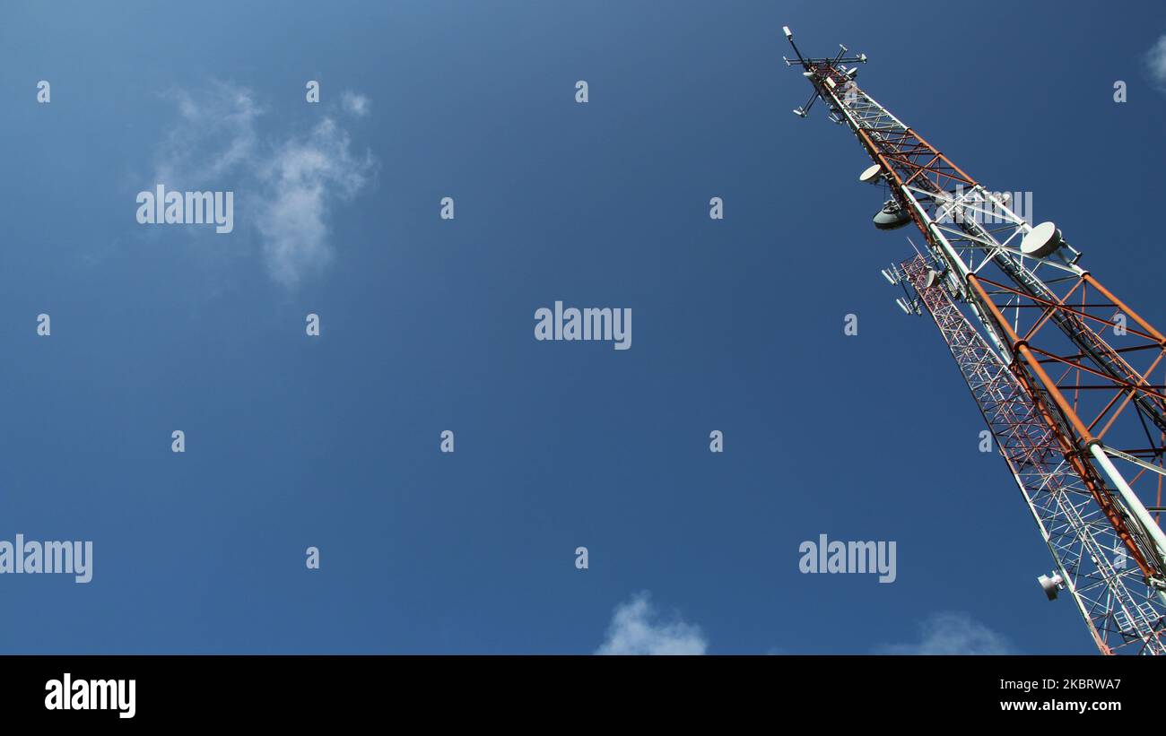 Cell phone network tower taken from a low angle against a clear blue ...