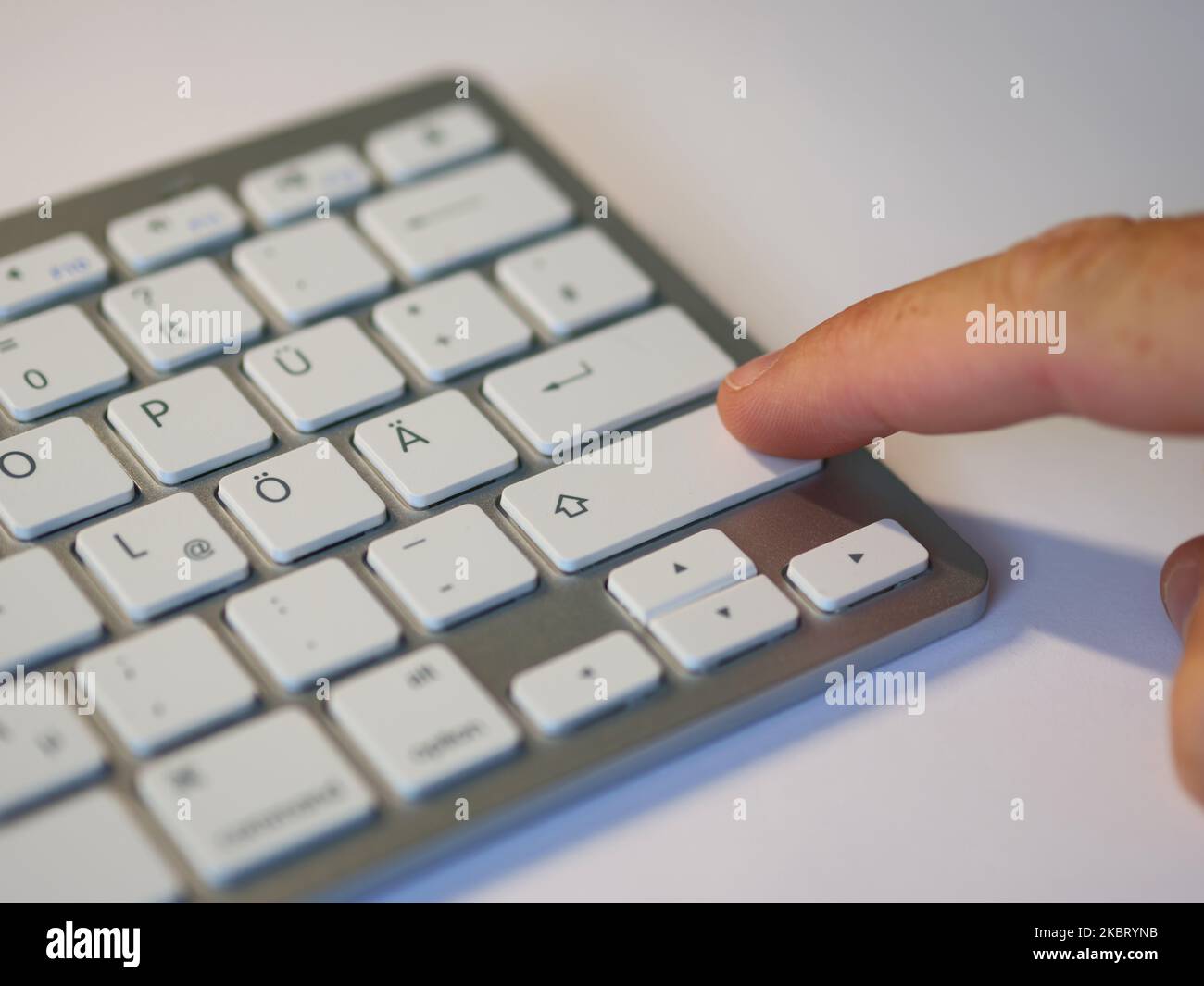 Keyboard with finger on the key Stock Photo - Alamy