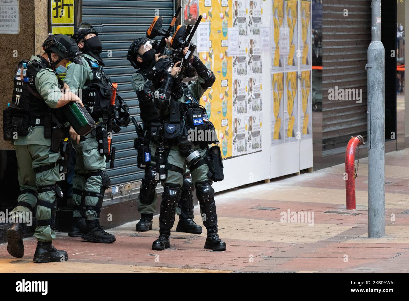 Hong Kong police fire pepper balls at a rooftop after bottles of water ...