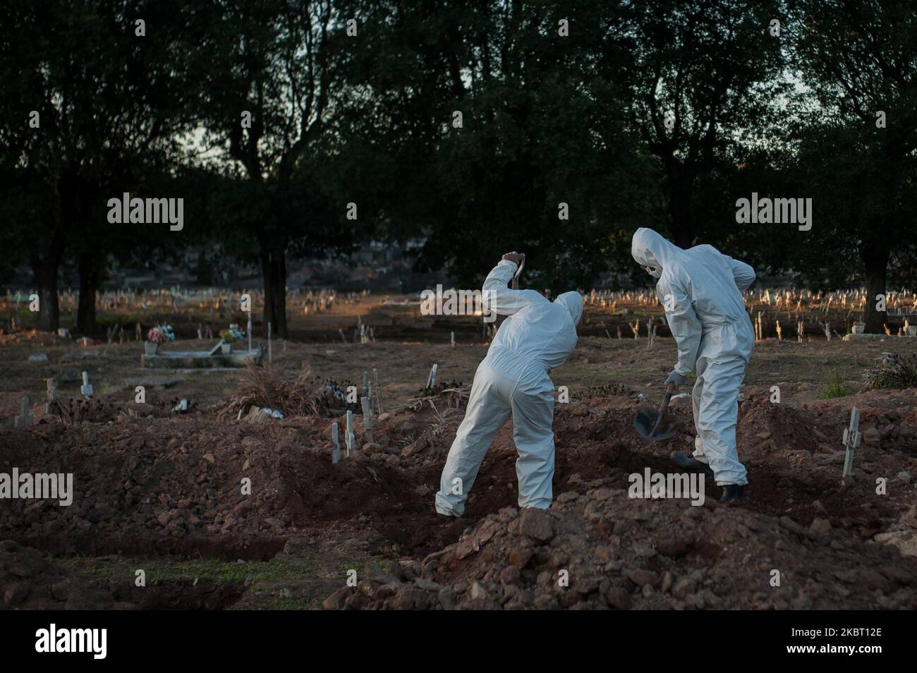 Agents of the funeral service (gravediggers) using personal protective ...
