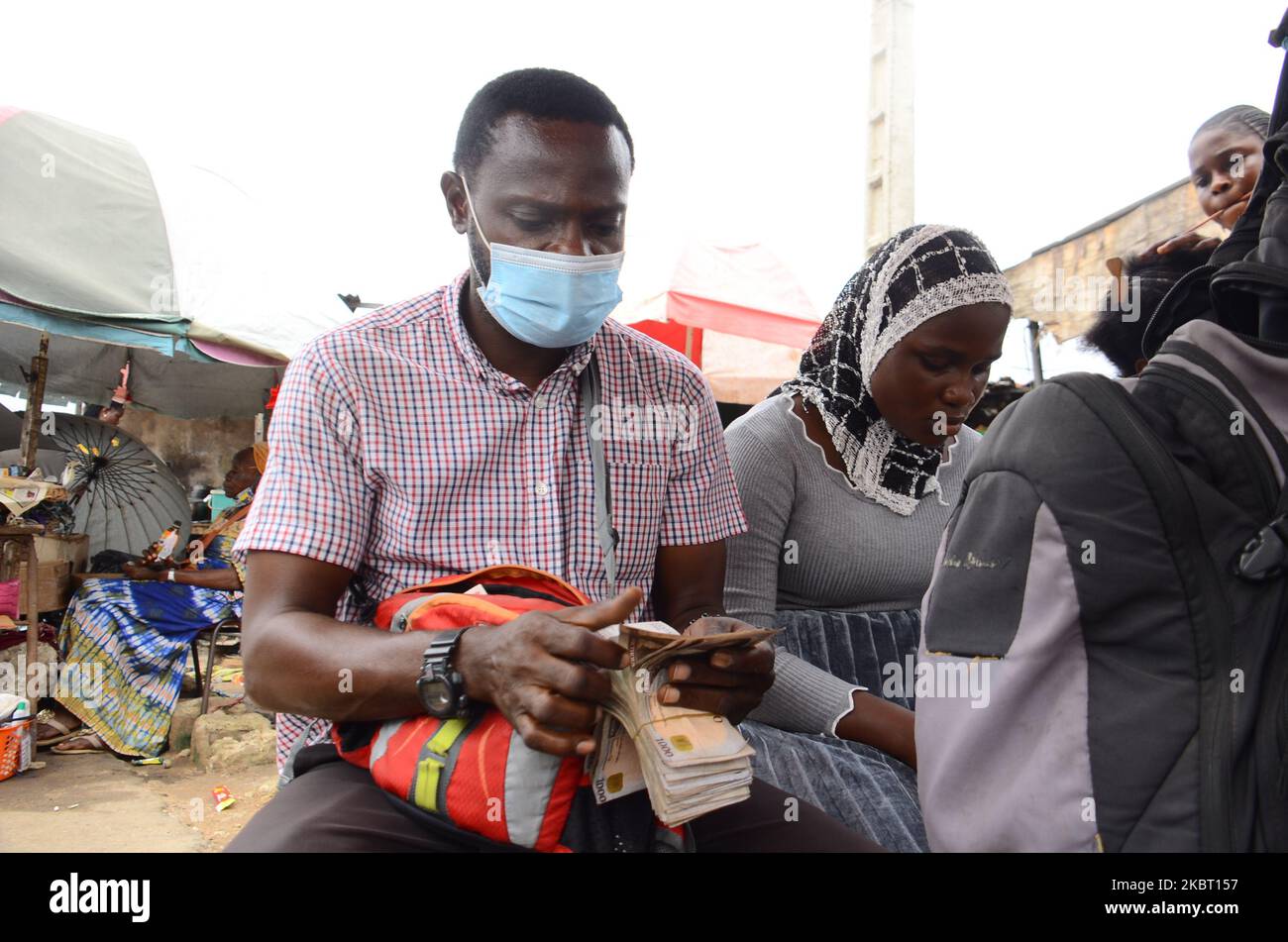 A traveller counting money a Nigerian currency (Naira) at the bus ...