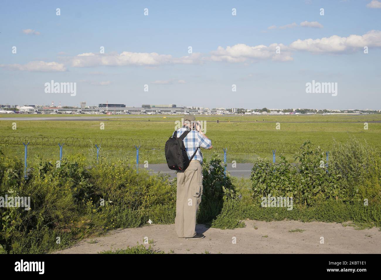 An airplane spotter is seen taking a photograph of a passing airplan on ...