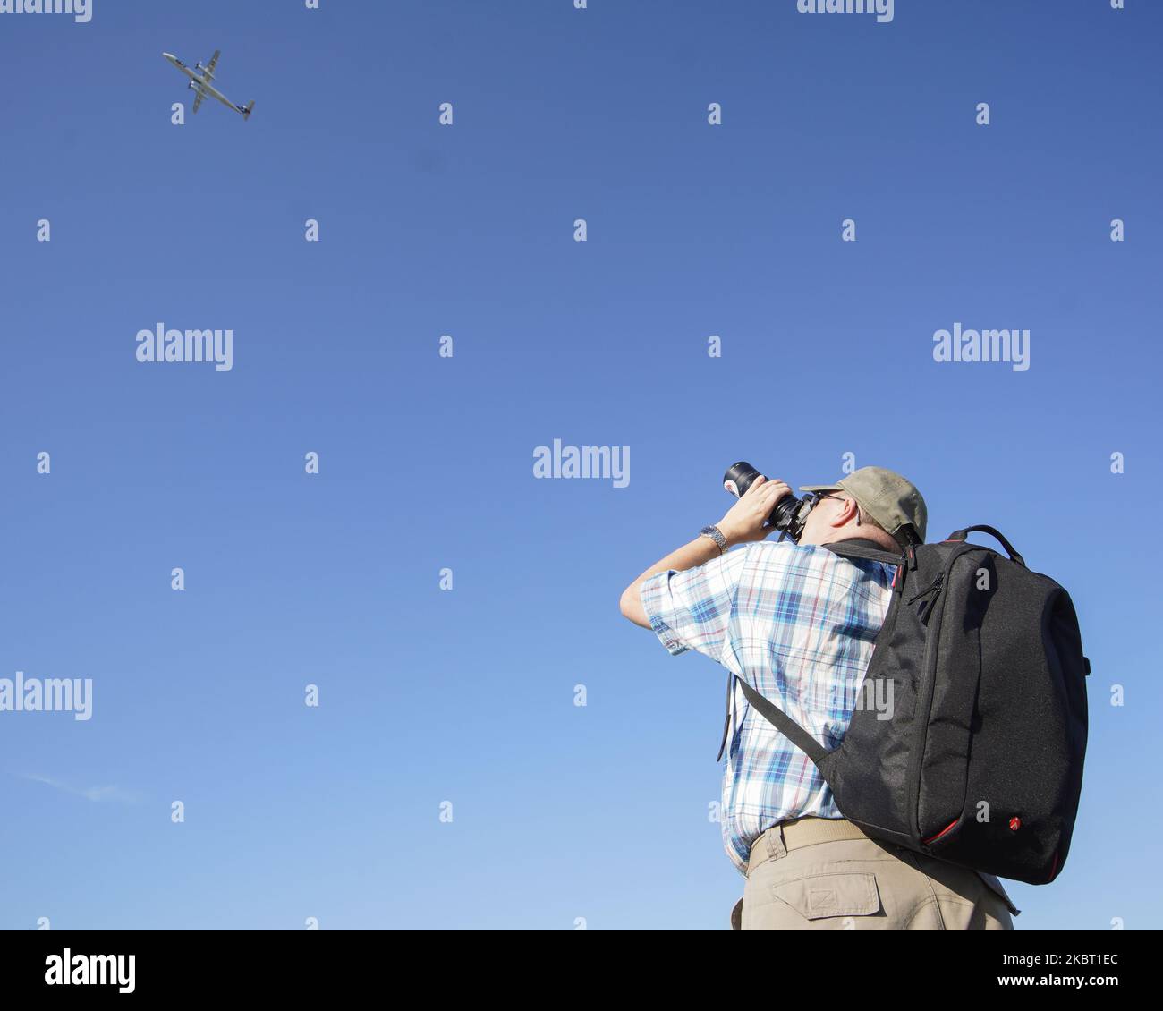 An airplane spotter is seen taking a photograph of a passing airplan on ...