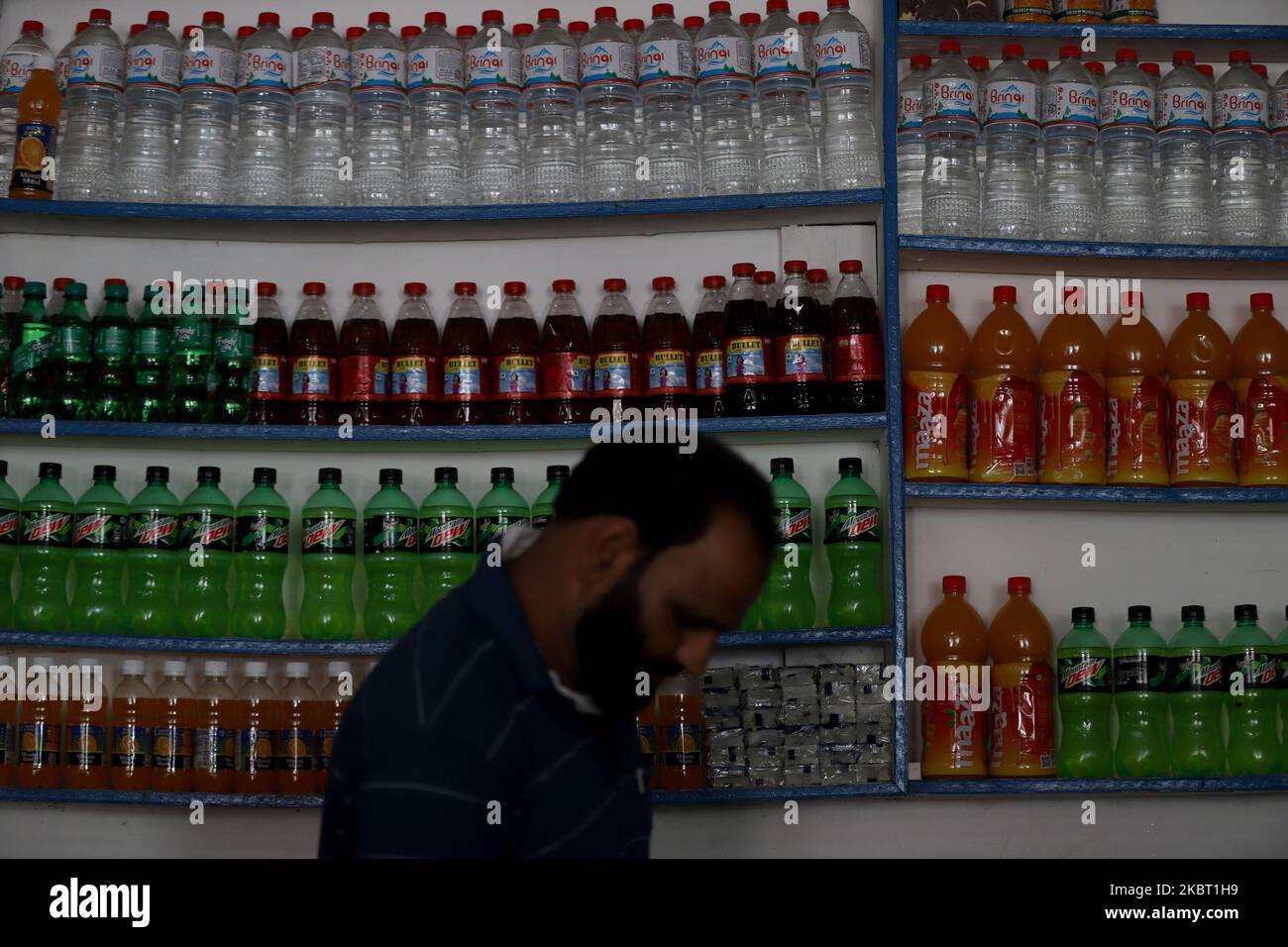Mountain Dew and Maaza fruit Juice bottles are seen on a shelf of a ...