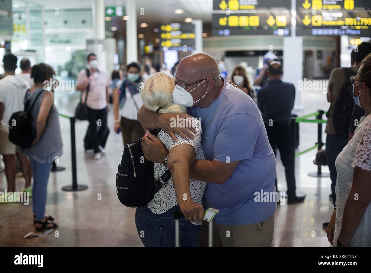 A couple hug when they meet after her arrival to Barcelona airport, on ...
