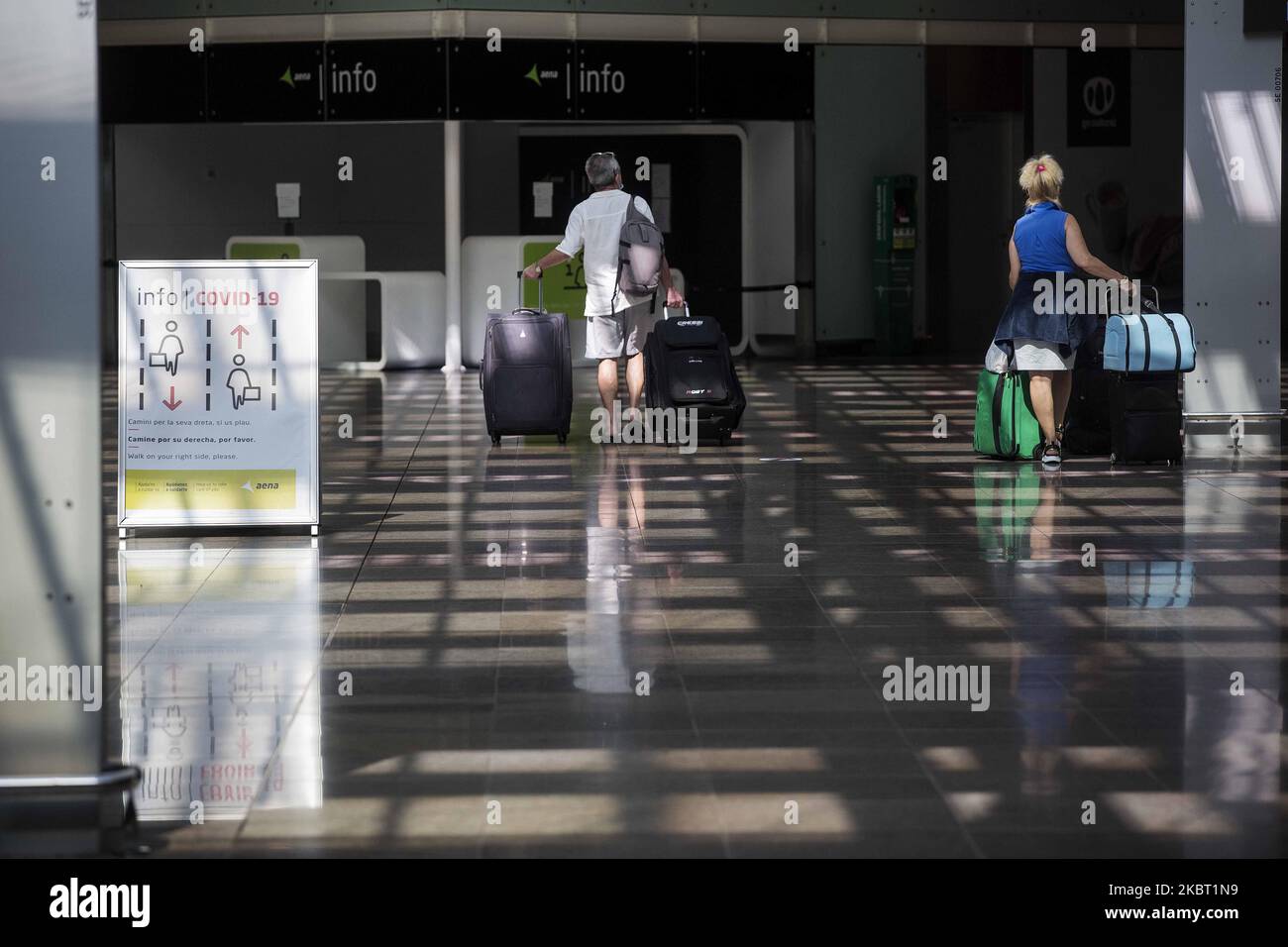 Passengers go to their boarding gate at Barceona airport on July 1, the ...