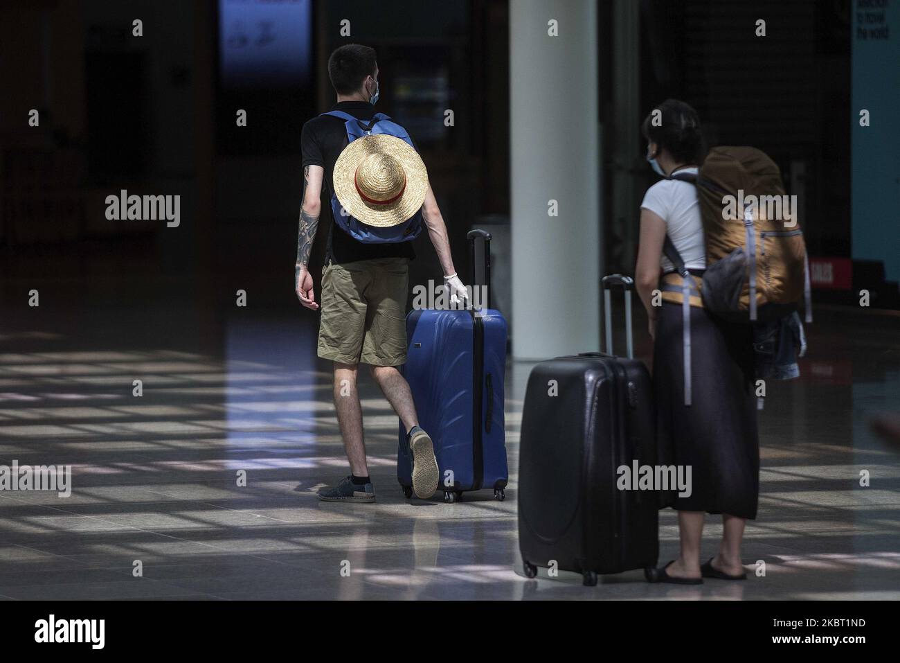 Passengers go to their boarding gate at Barceona airport on July 1, the ...