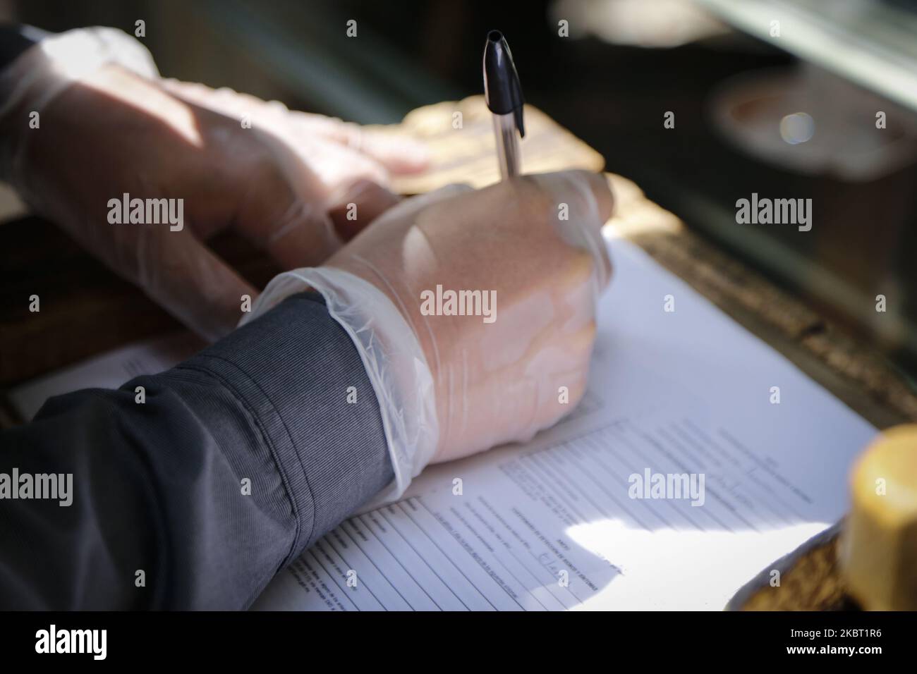 A worker fills out a government-issued form for client registration on ...