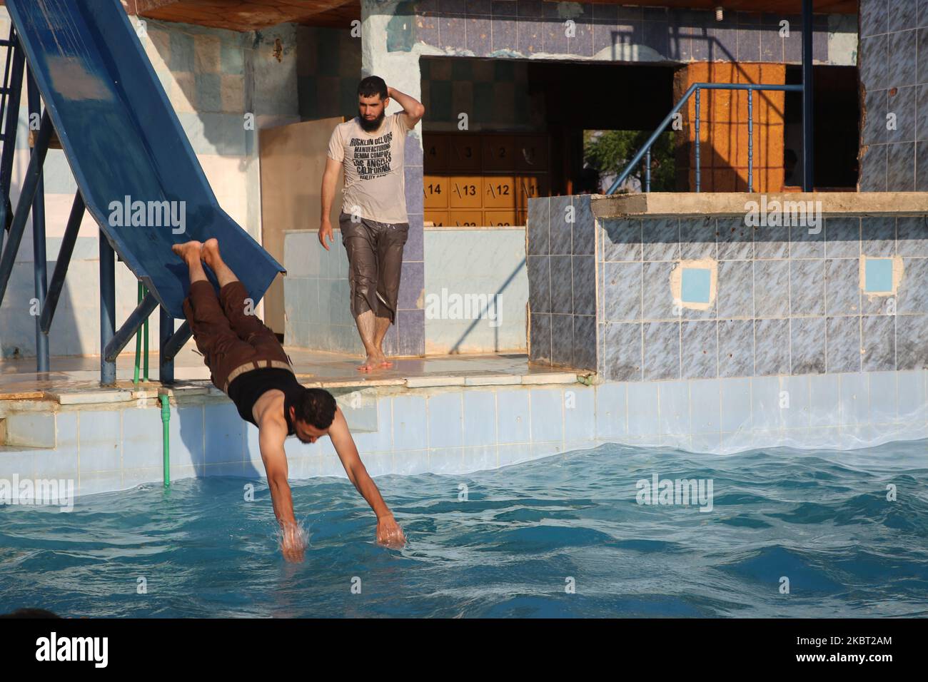 People playing in a swimming pool in a resort in Idlib Governorate ...