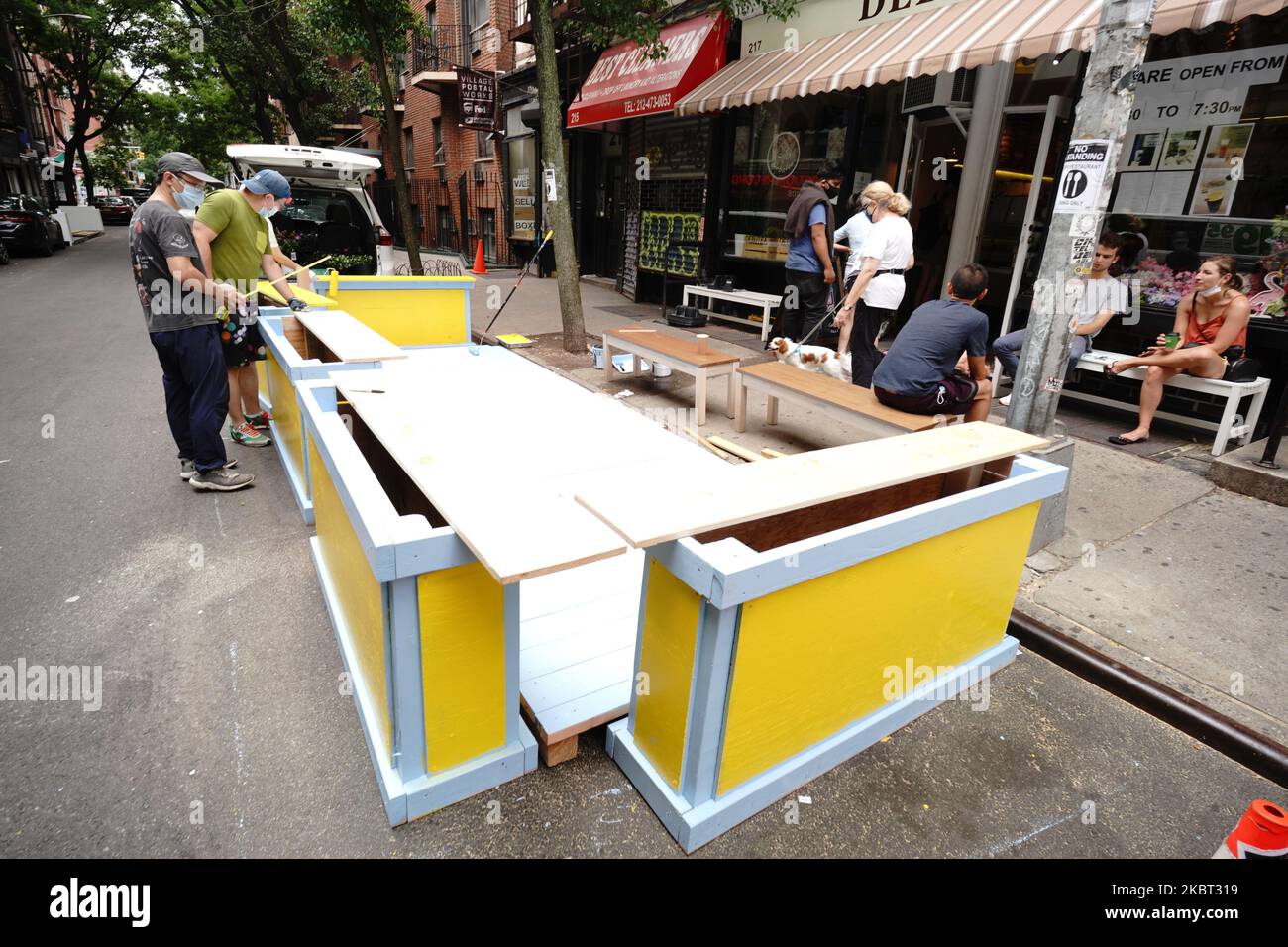 Carpenters are seen building dining kits outside a restaurant in New ...