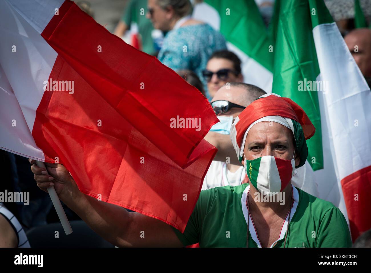 People brandish Italian national flags as they attend a joint rally ...