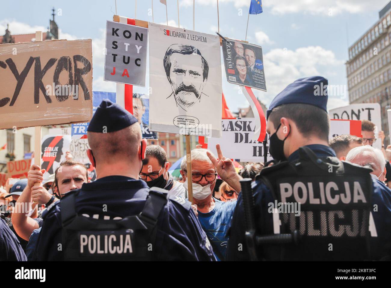 Protesters hold banners and police take security measures while Andrzej ...