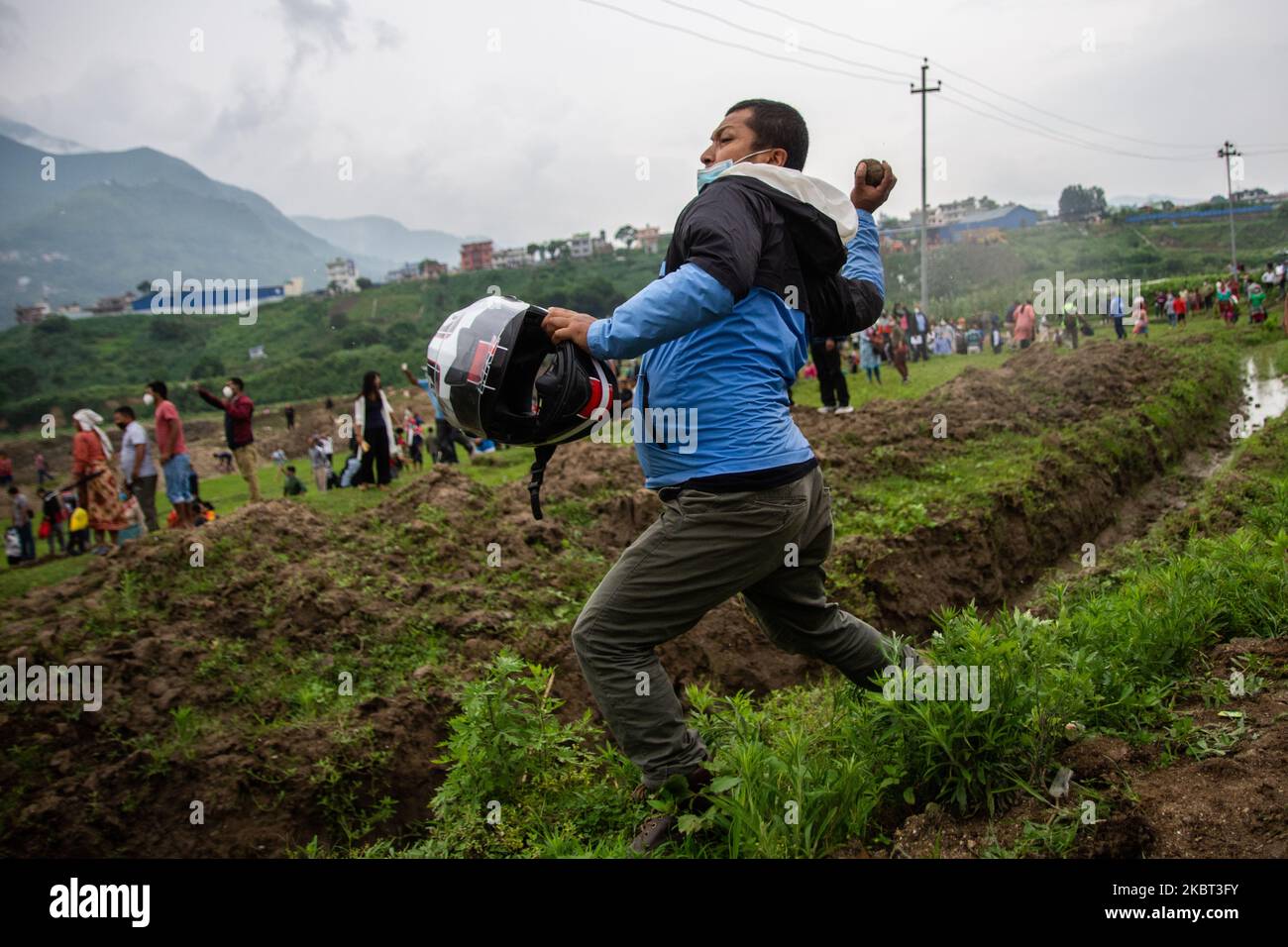 A protestor throws stone at policemen during a protest that turned into ...