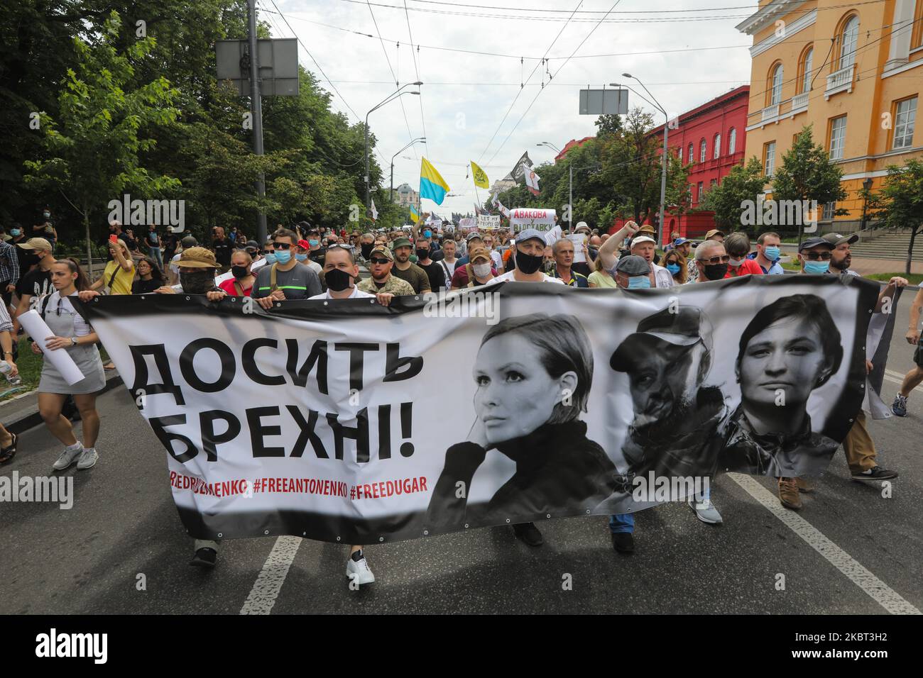 People hold a banner with the portraits of accused in killing as they ...