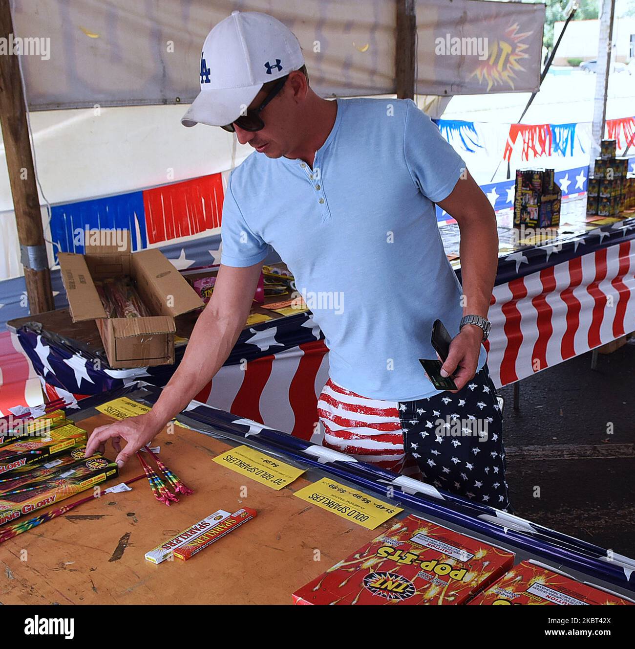 A man selects fireworks for purchase from a vendor in a temporary tent ...