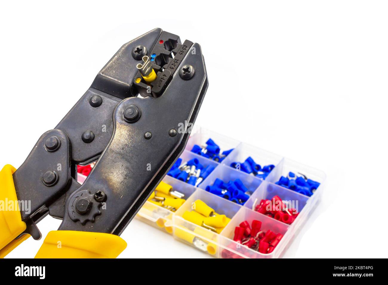 crimping isolated connectors with a old yellow tool on white background ...