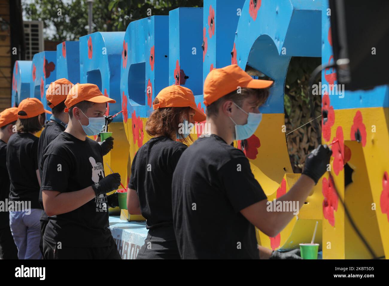 Young people paint with poppies the city limit sign Sloviansk with ...