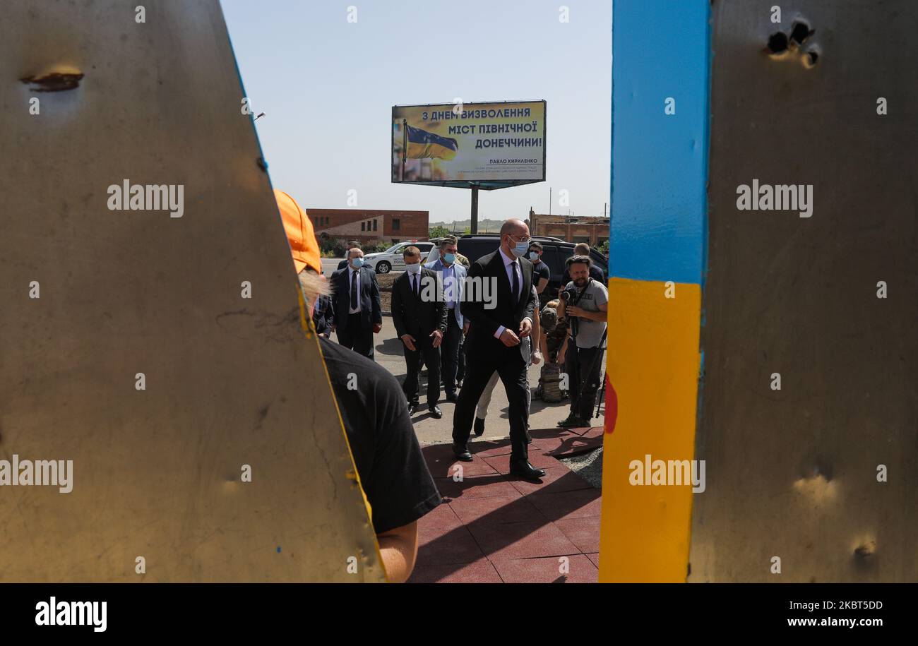 Prime minister of Ukraine Denys Shmyhal (C) are seen near the city ...