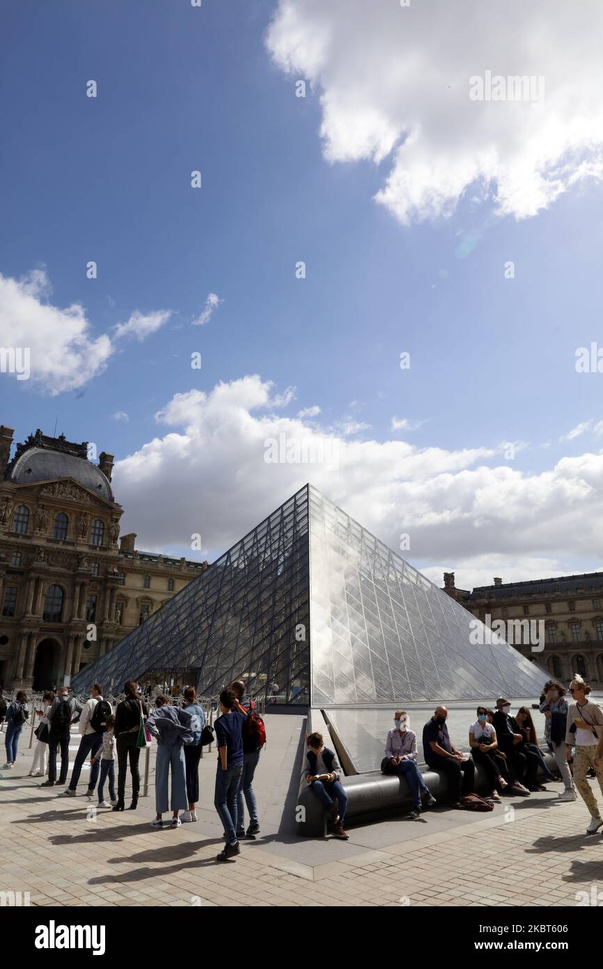 Visitors queue observing social distancing markings outside the Louvre ...