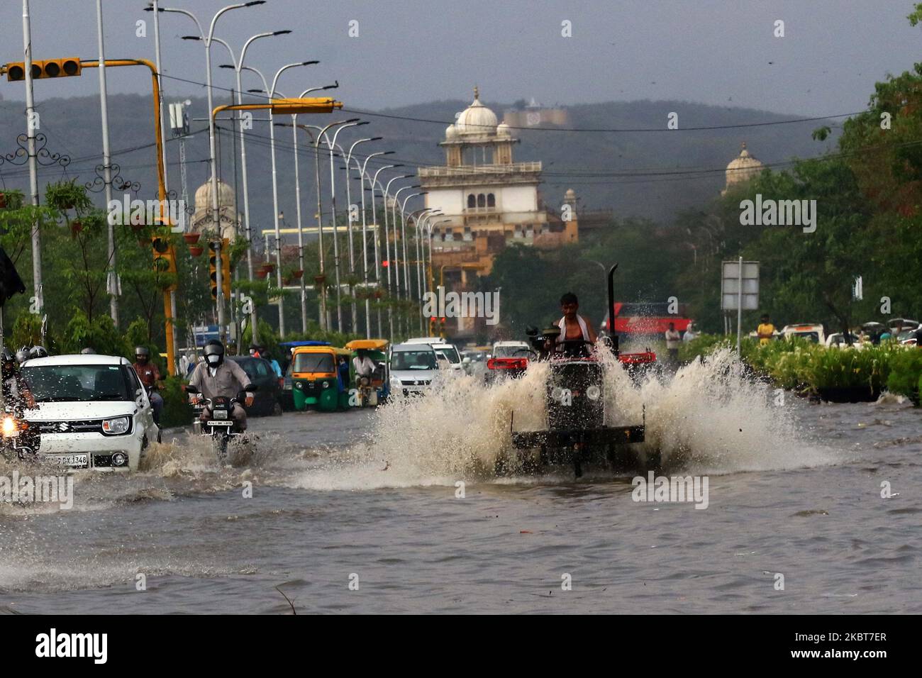Commuters pass through a waterlogged street following heavy rain, in ...