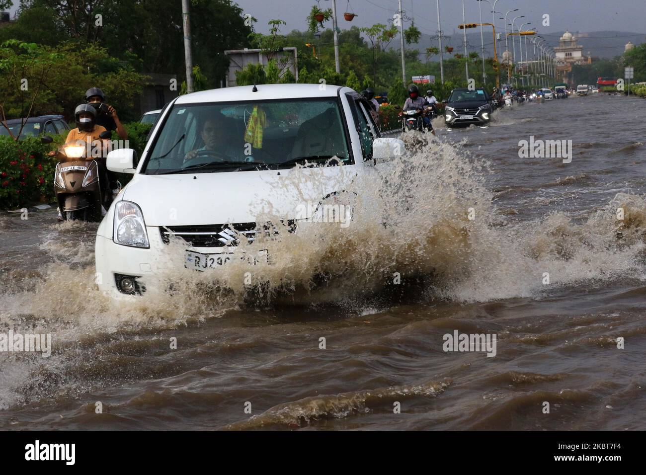 Commuters pass through a waterlogged street following heavy rain, in ...