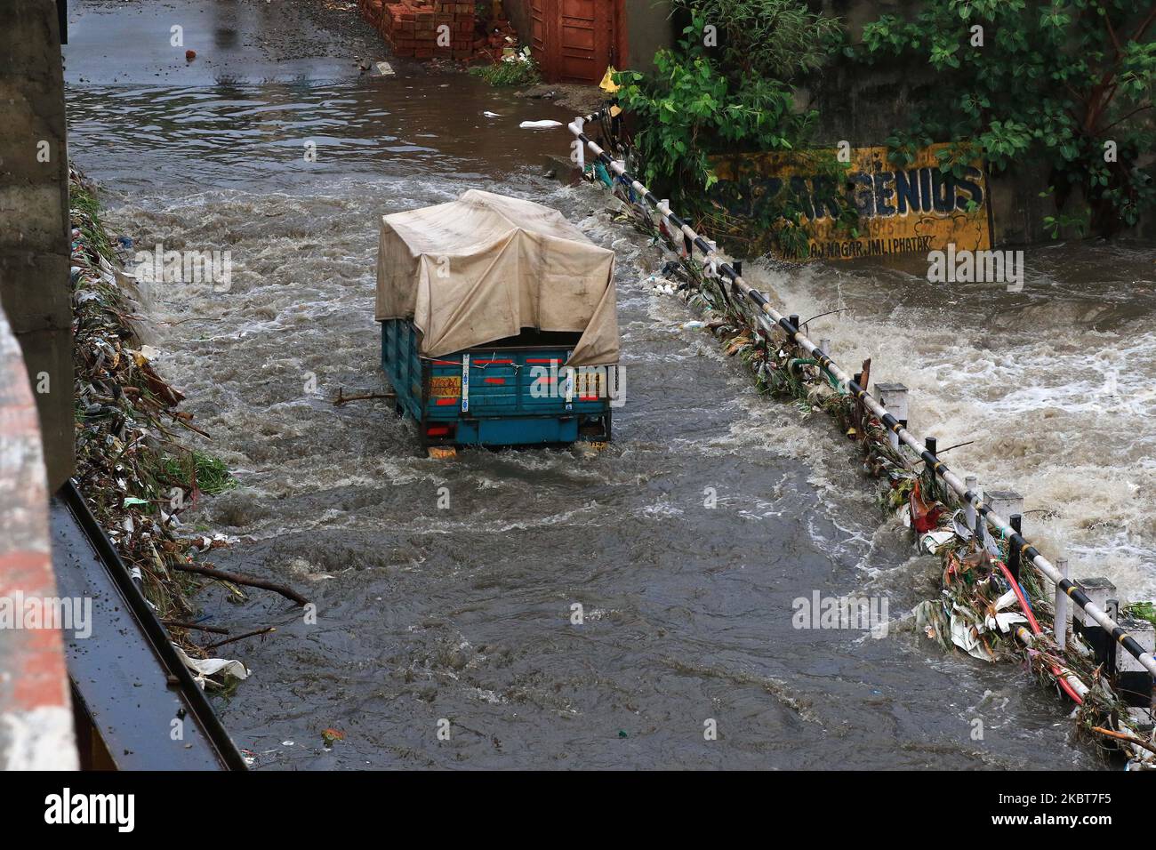 A tempo stuck in a waterlogged street following heavy rain, in Jaipur ...