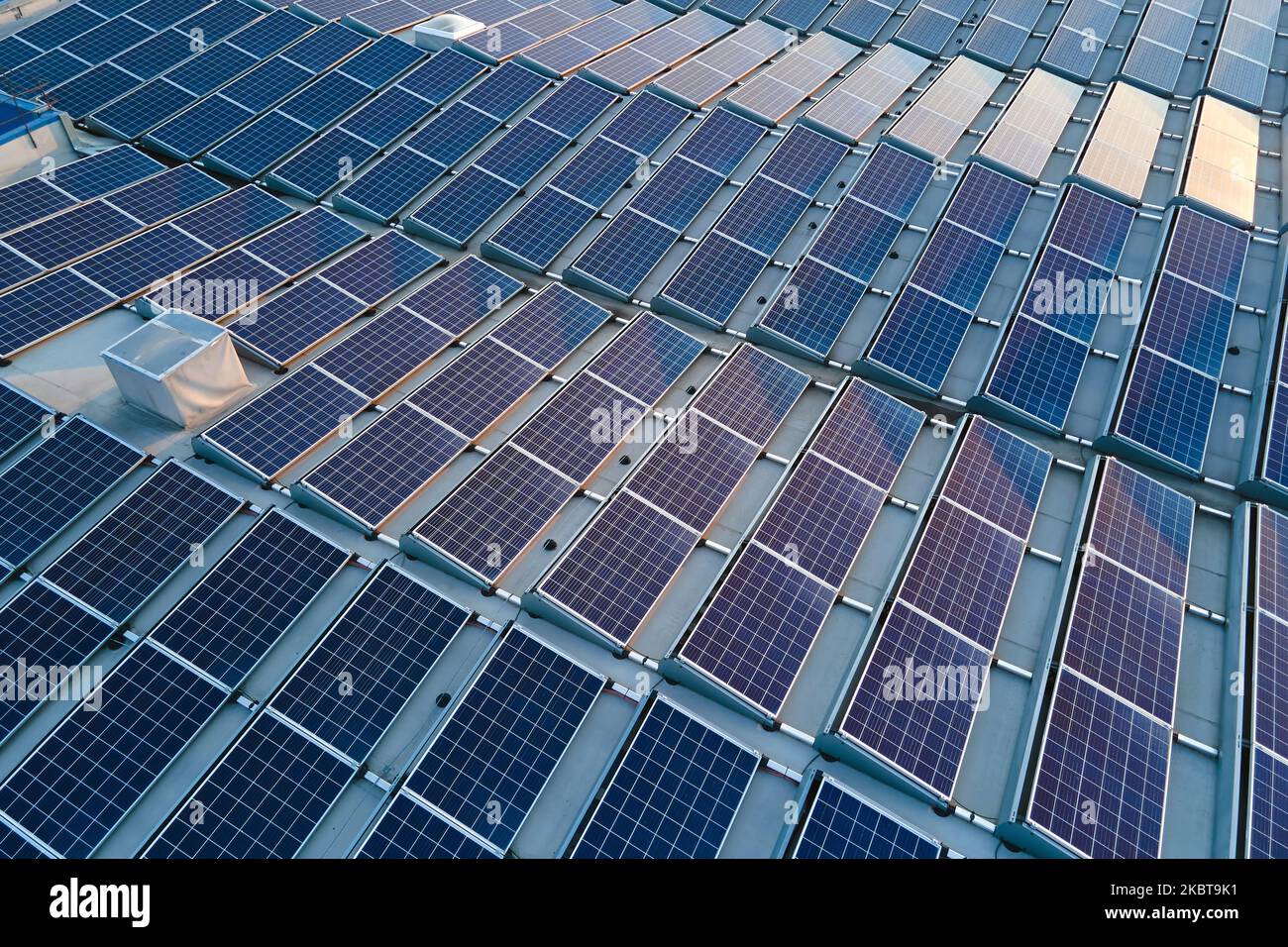 Aerial view of blue photovoltaic solar panels mounted on industrial ...