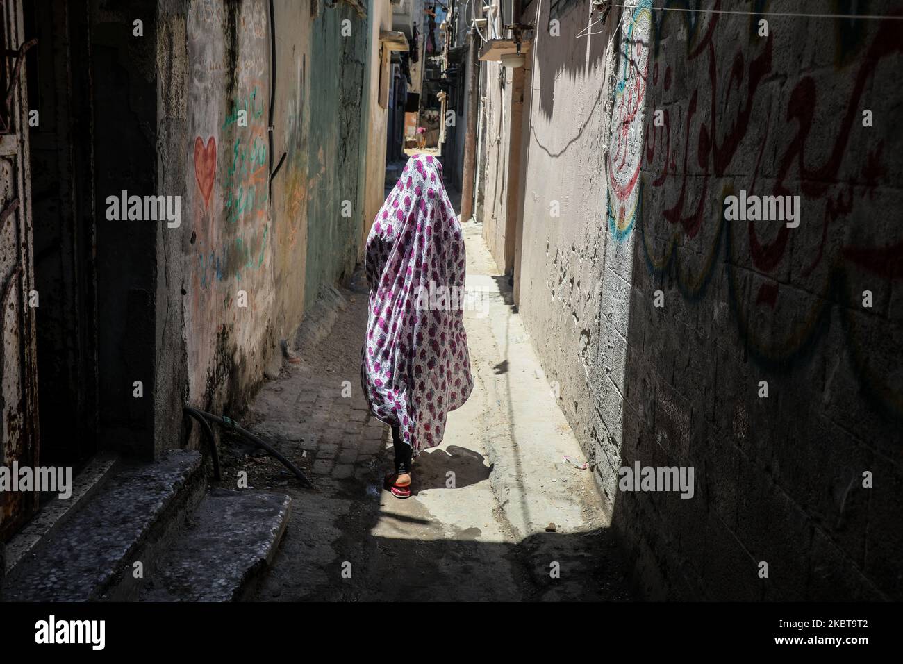 A Palestinian girl walks outside her family's house at al-Shati camp ...