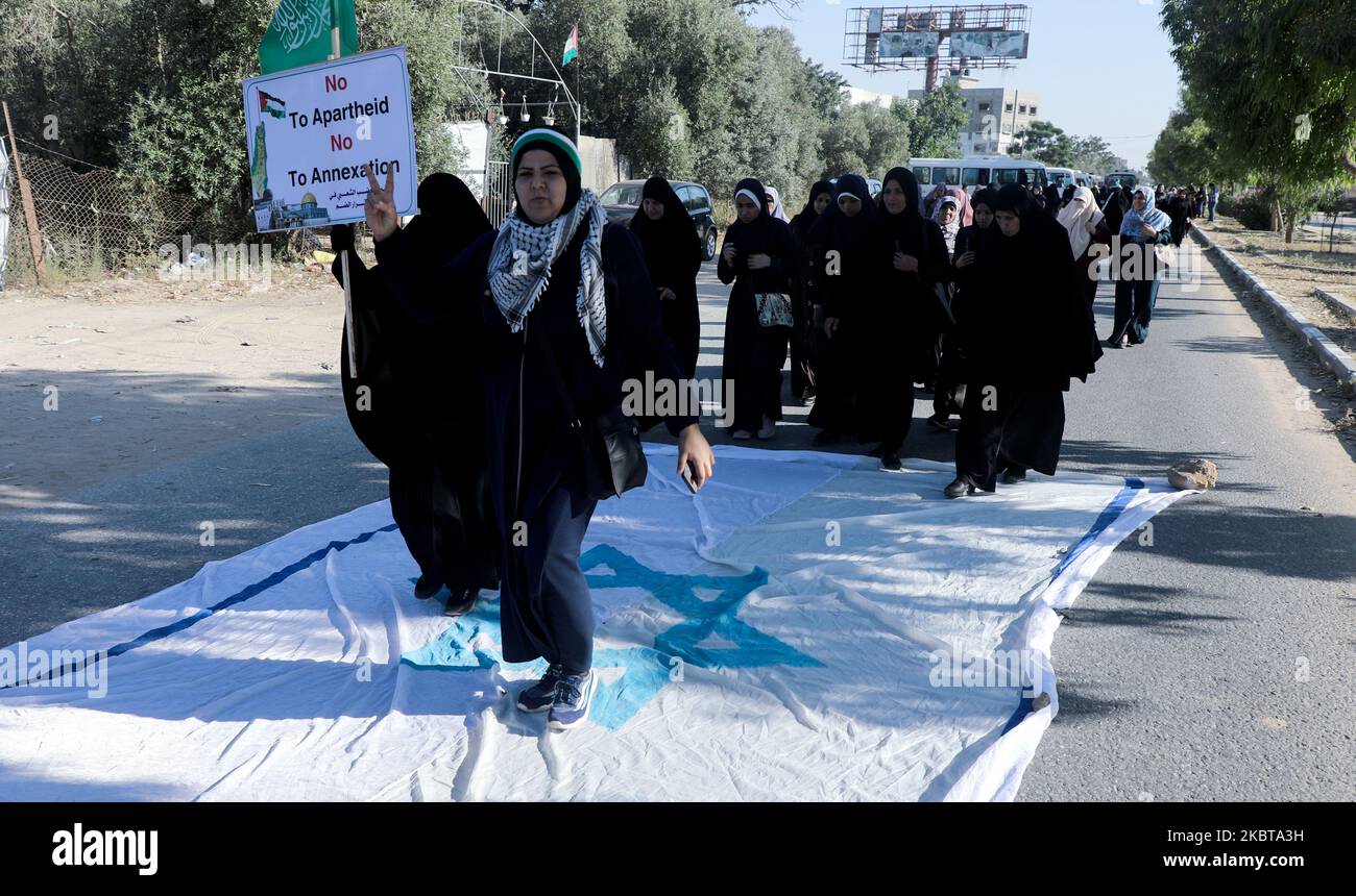 Palestinian women walk on an Israeli flag take part in a protest ...