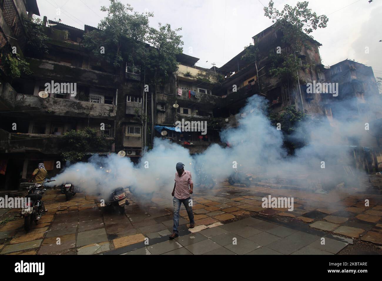 A man walks through smoke after the area was fumigated by a municipal ...