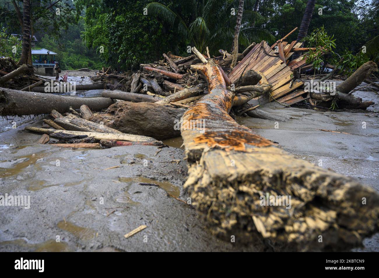 Residents crossed near the ruins of a house destroyed by a flash flood ...