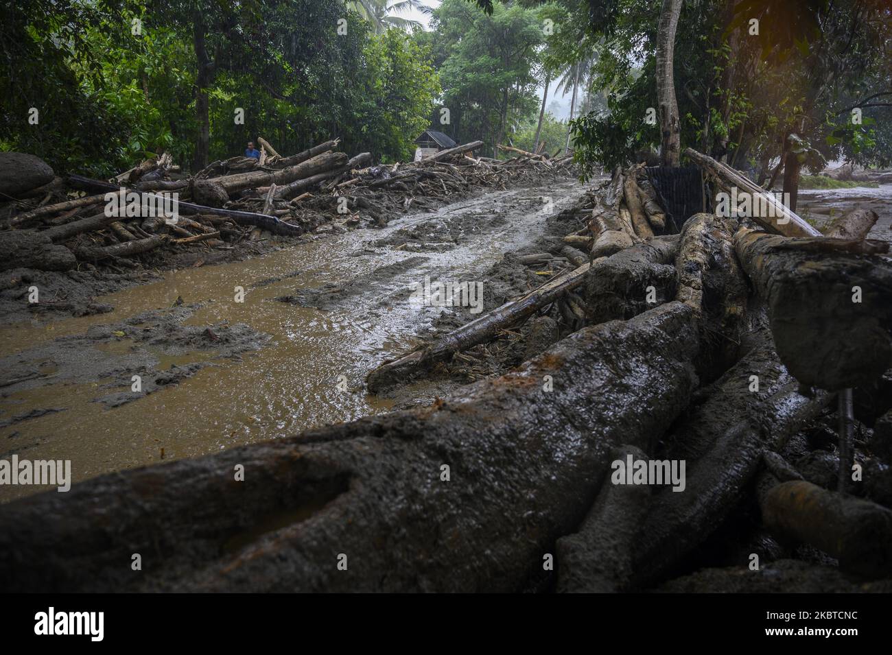 Residents crossed near piles of wood and mud from houses that were ...