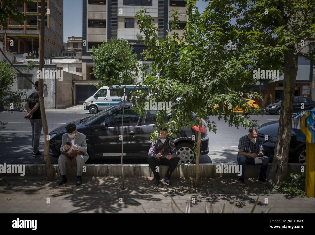 Iranian men wearing protective face masks wait out of a virology ...
