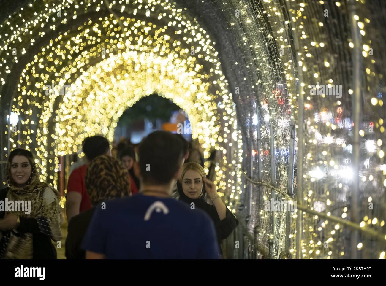 Iranian youth walk along a street-side in northern Tehran at night, May ...
