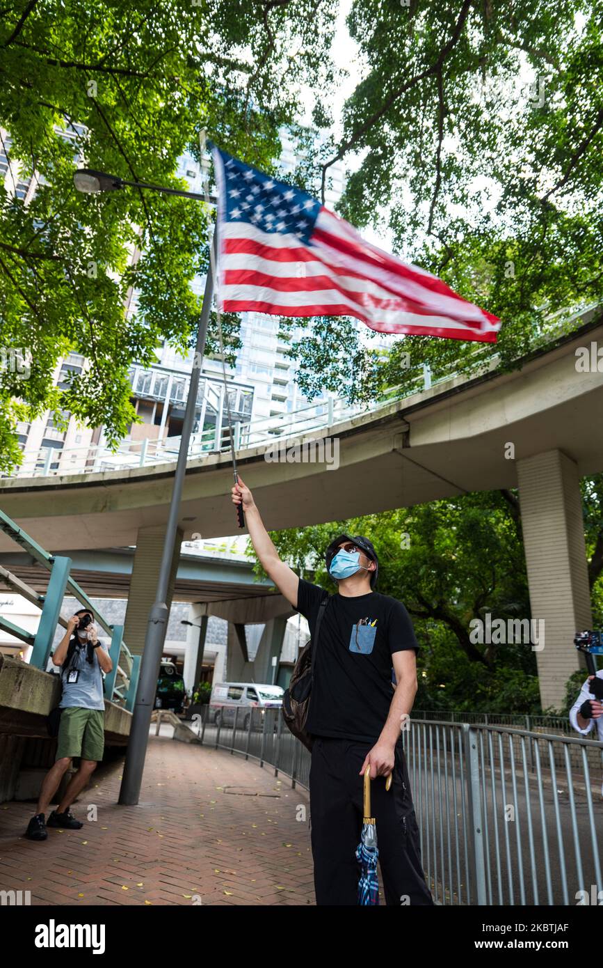 A protester deploys a US flag at some distance of the US Consulate on ...