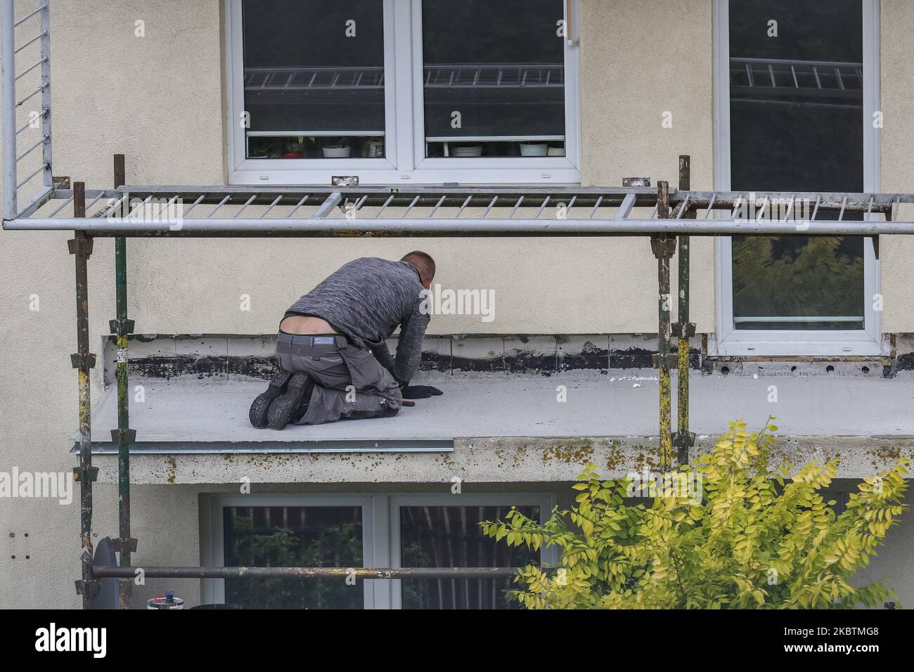 Construction worker during balcony repair work in an apartment block ...