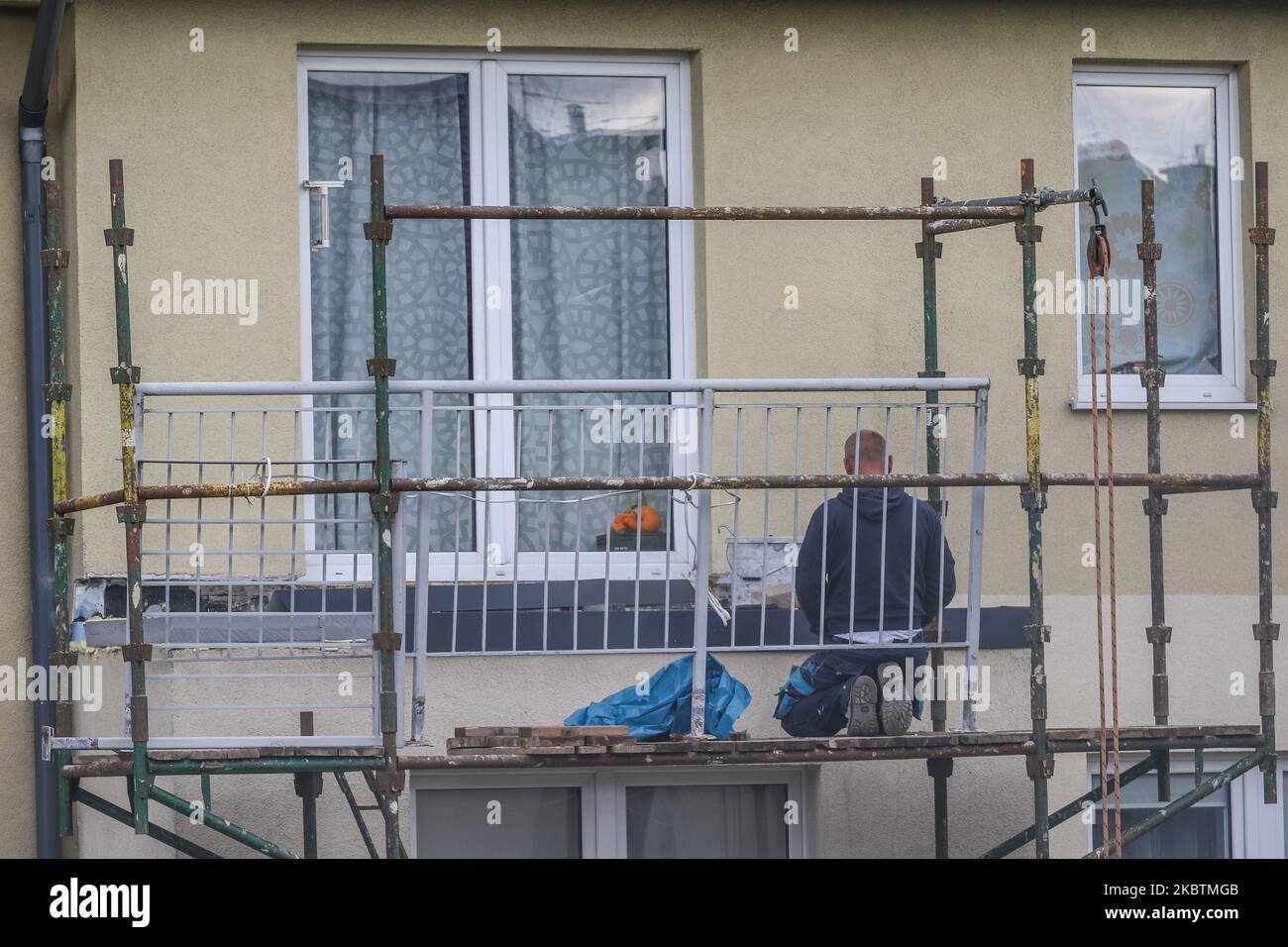Construction worker during balcony repair work in an apartment block ...
